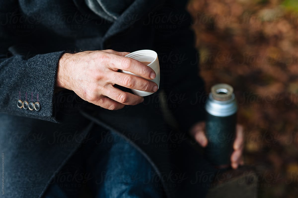 "Man Holding A Cup Of Tea From A Flask" by Stocksy Contributor "Suzi ...