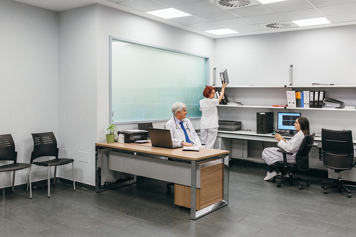 "Medics Working In Office" by Stocksy Contributor "VICTOR TORRES" - Stocksy