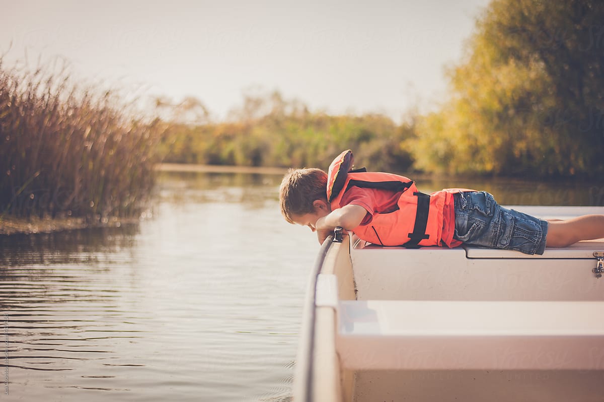 "Young Boy Observing The Surface Of River During A Boat Trip" by ...