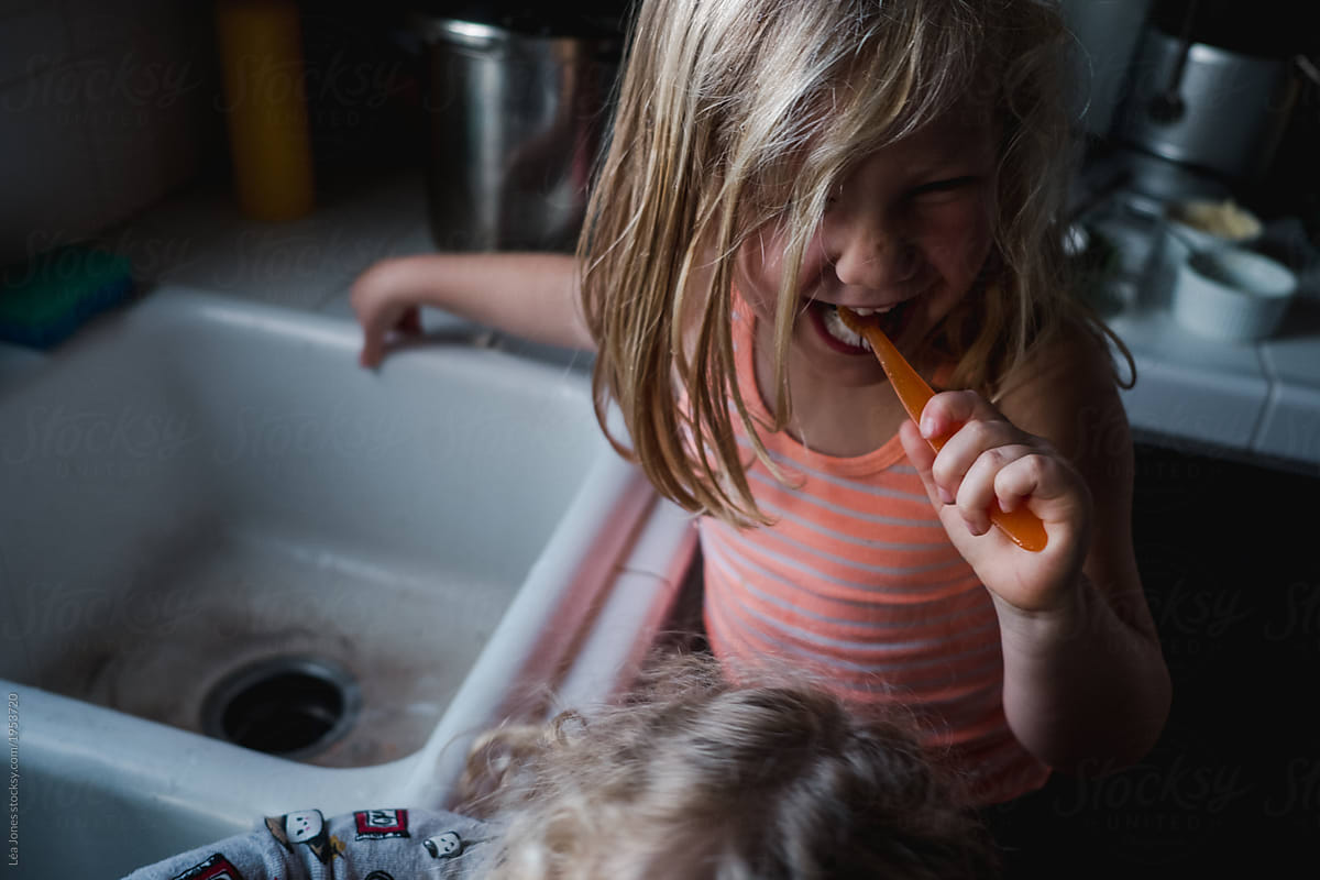 Child Brushing Teeth At Sink