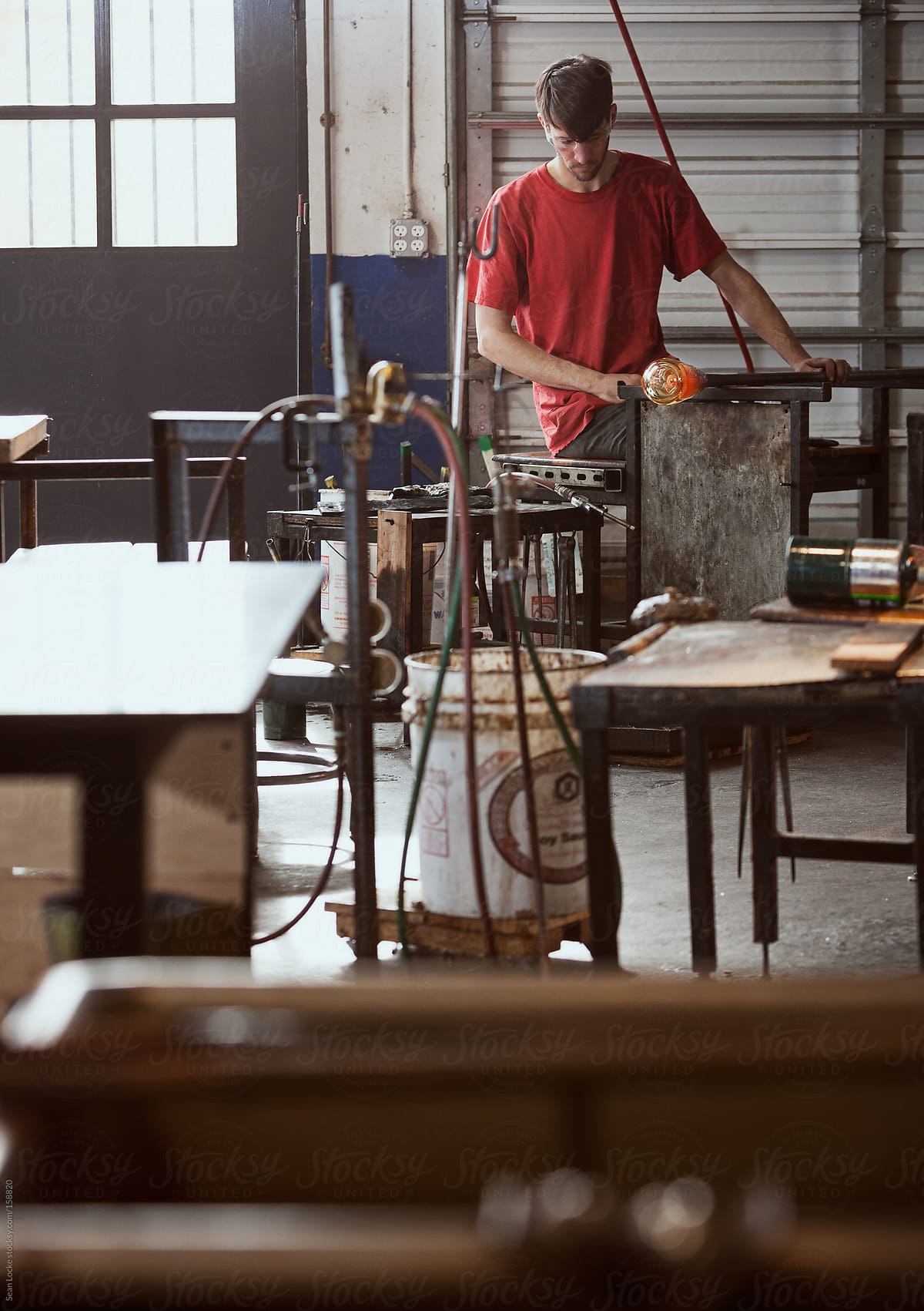 "Glass: Artist In Workshop Shaping Glass" by Stocksy Contributor "Sean ...