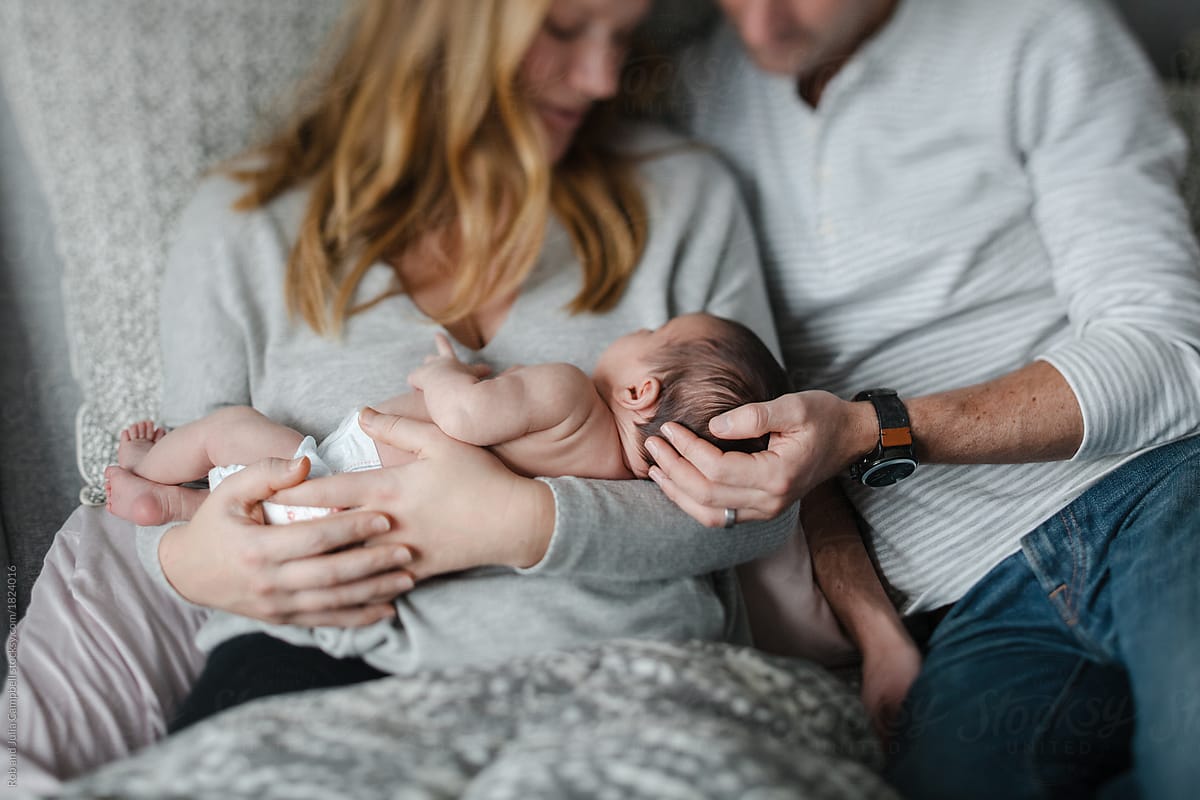 "Happy New Family Of Three Cuddling In The Bed Together At Home" by ...
