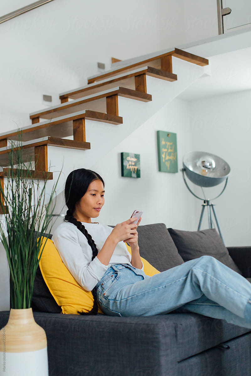"Woman Using Phone At Home" by Stocksy Contributor "Marko" - Stocksy