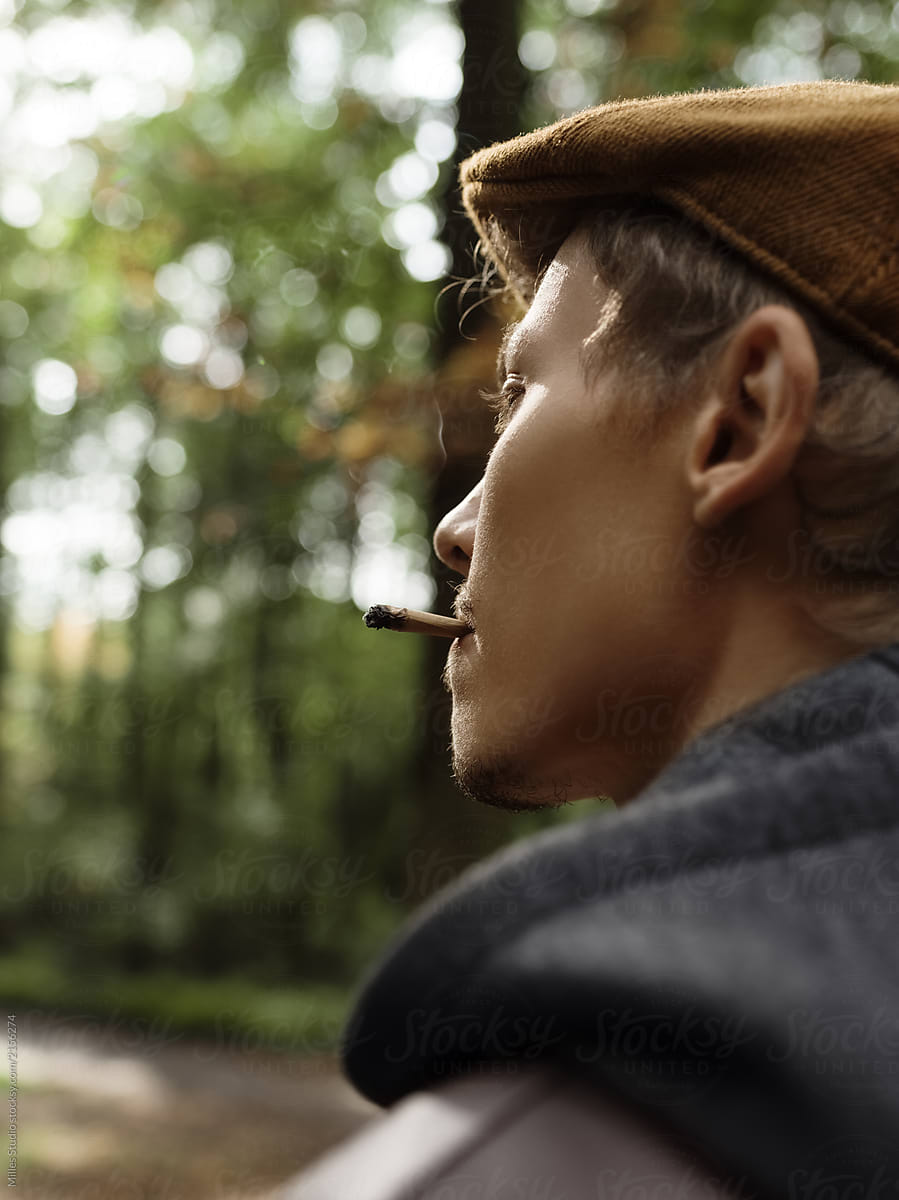 "Man Smoking Blunt In Woods" by Stocksy Contributor "Milles Team" - Stocksy