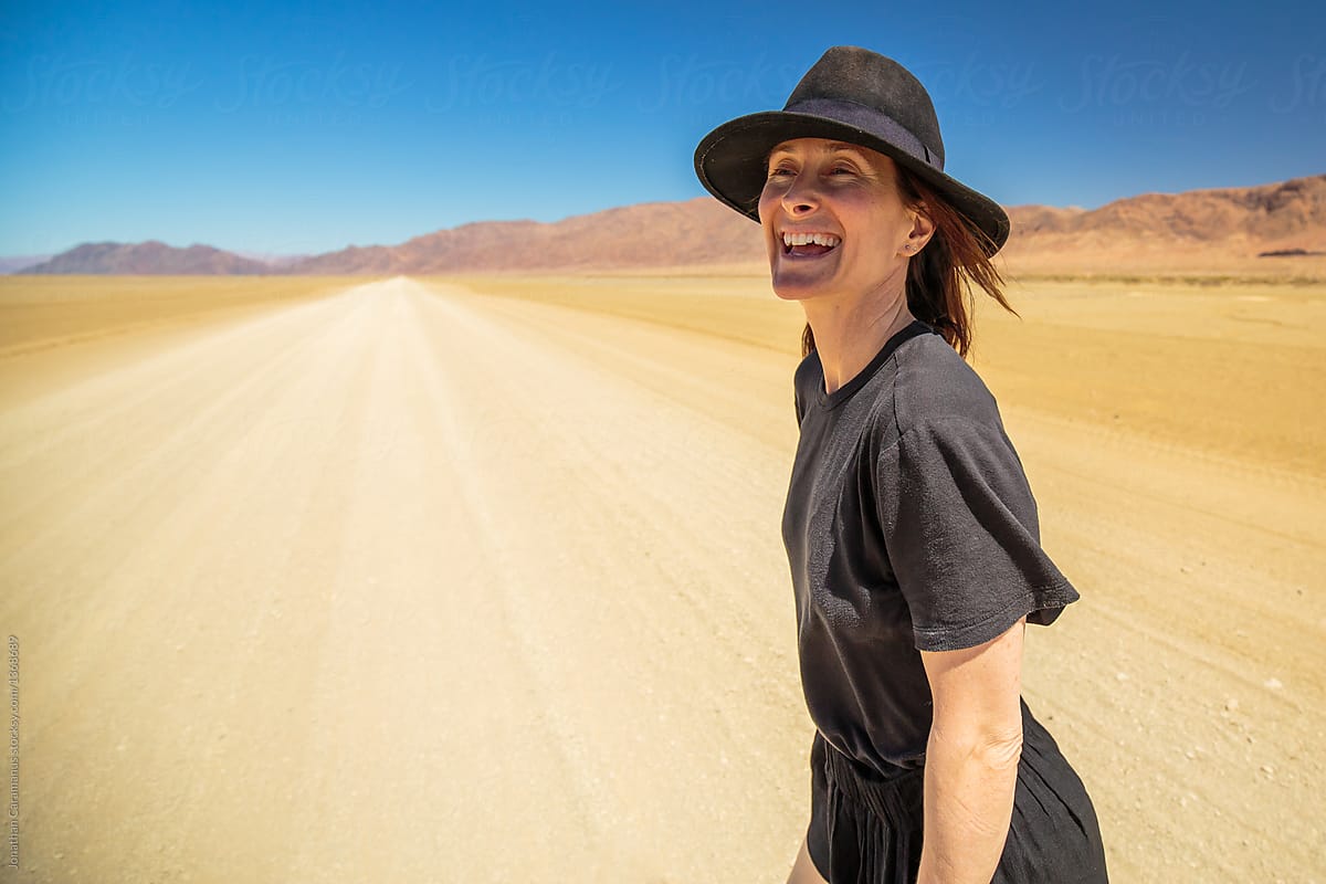 "Woman On Dry Dusty Dessert Road Wearing Black Surrounded By Mountains ...