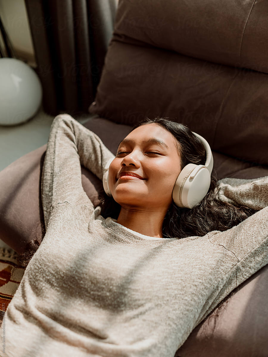 "Relaxed Woman Enjoying Music With Headphones At Home" by Stocksy ...