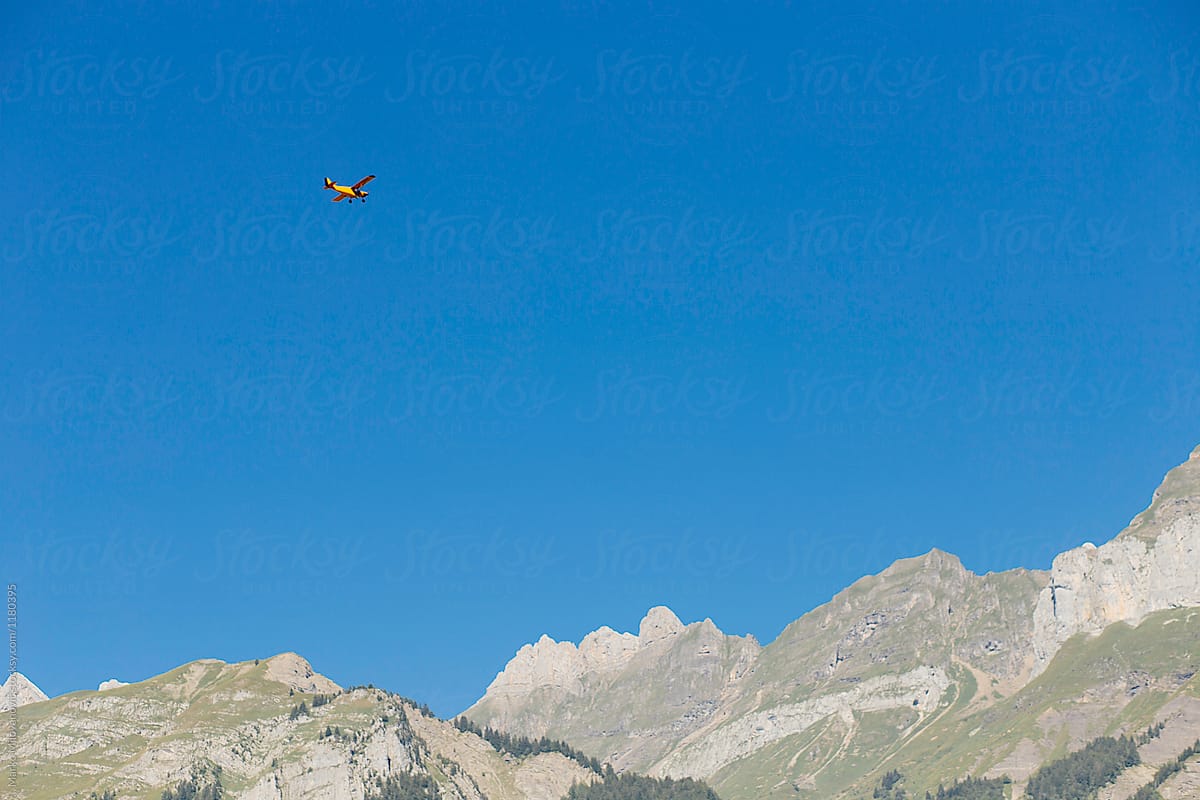 "Airplane Flies Over The Mountains" by Stocksy Contributor "Marko ...