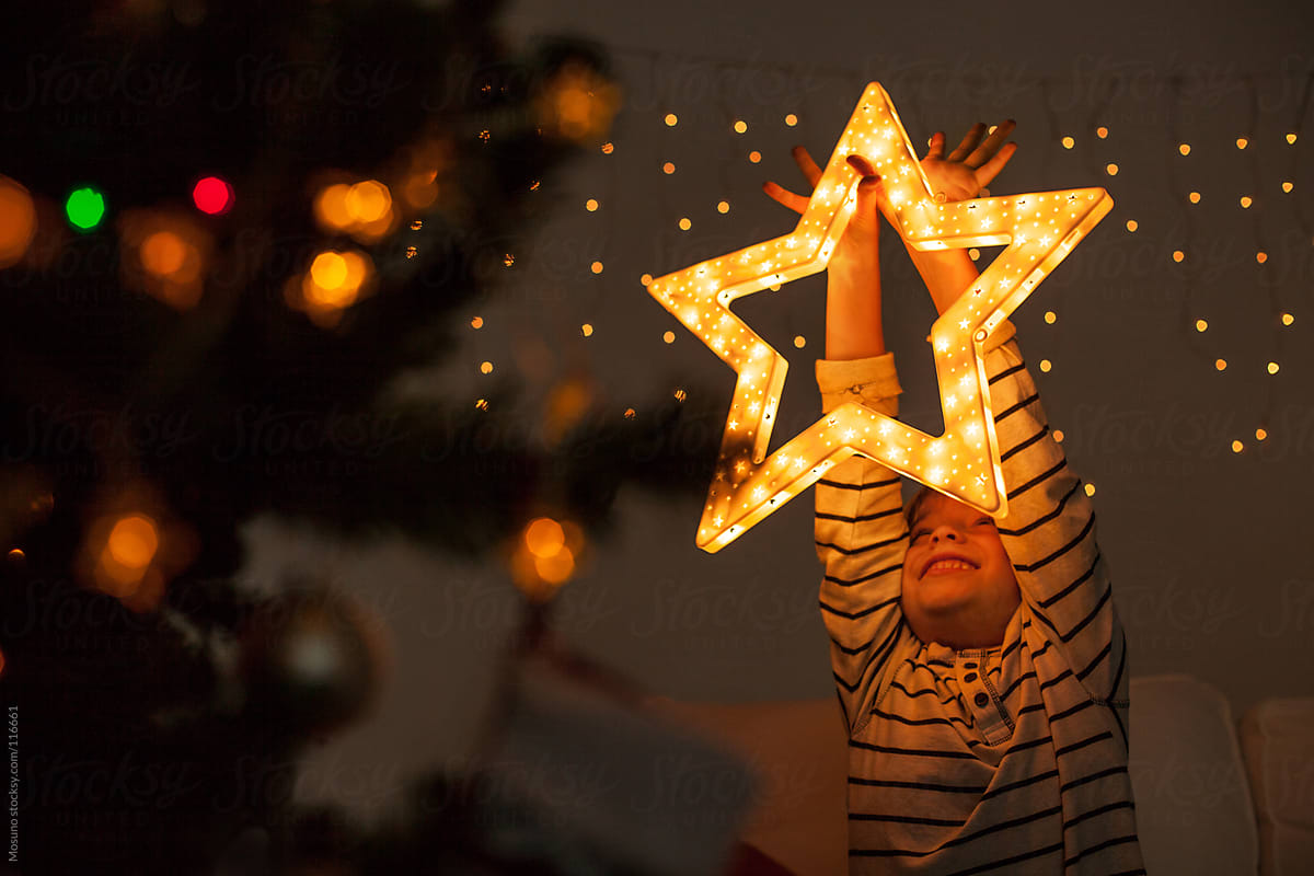 "Cute Boy Holding Christmas Star" by Stocksy Contributor "Mosuno" - Stocksy