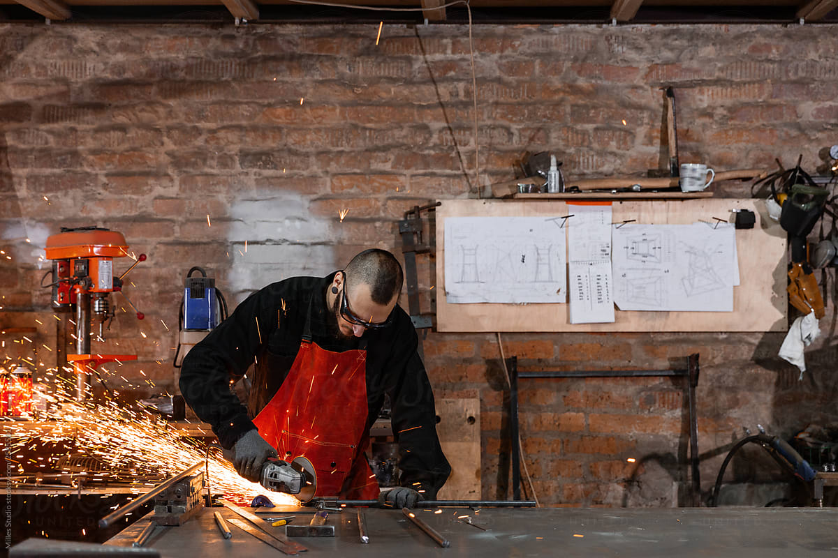 "Focused Man Cutting Metal Pieces" by Stocksy Contributor "Milles Team ...