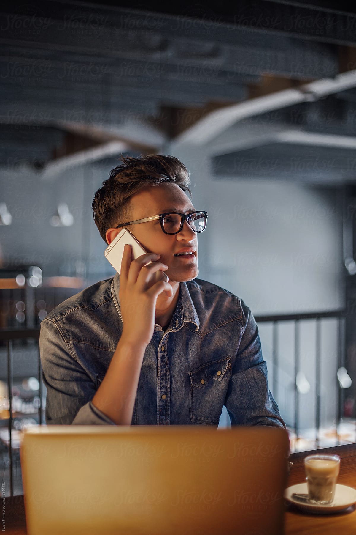 "Man Using Phone In Coffee Shop." by Stocksy Contributor "Studio Firma ...