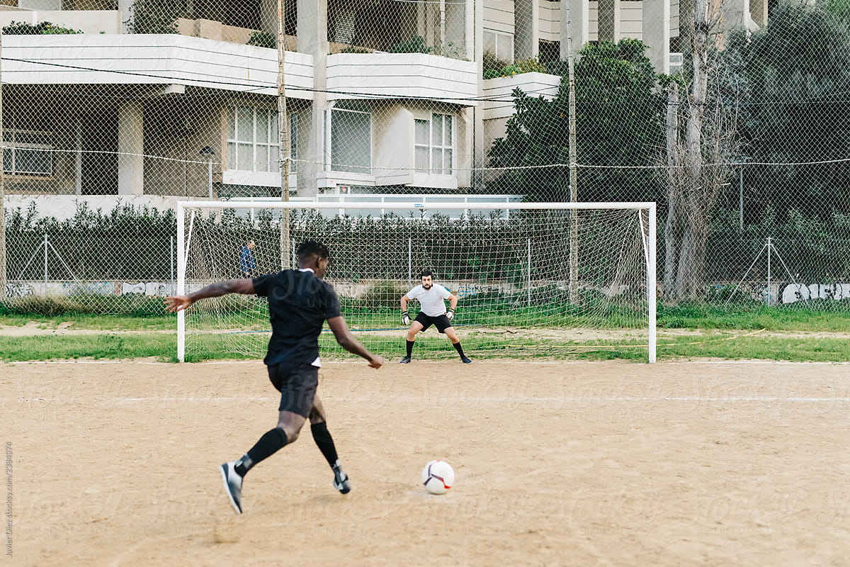 "African American Man Kicking Penalty Against Goalkeeper In Yard" by ...