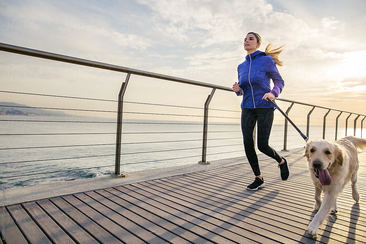 "Woman Running With Her Dog On The Bridge At Morning." by Stocksy ...