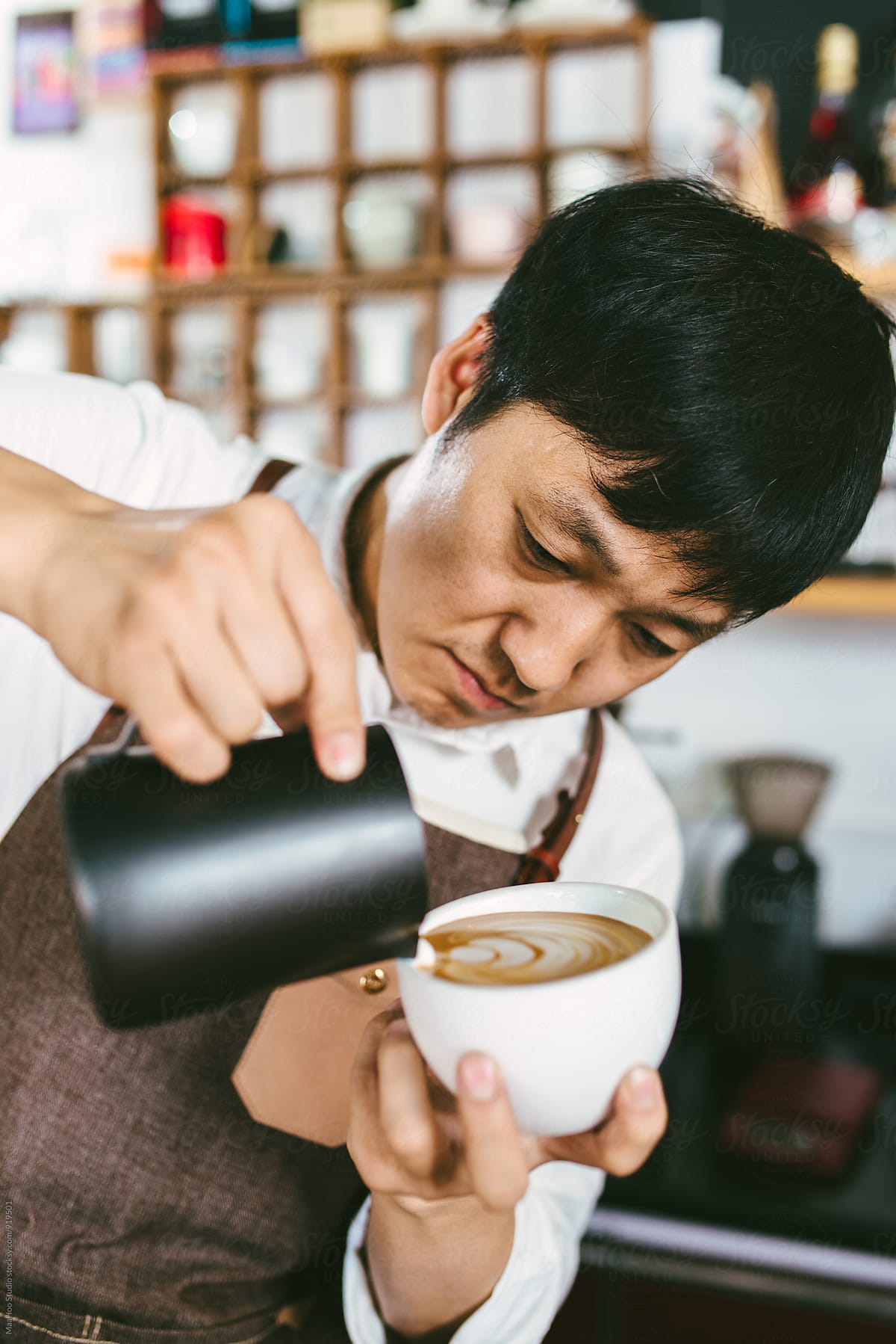 "Coffee Shop Owner Making Latte" by Stocksy Contributor "MaaHoo" - Stocksy
