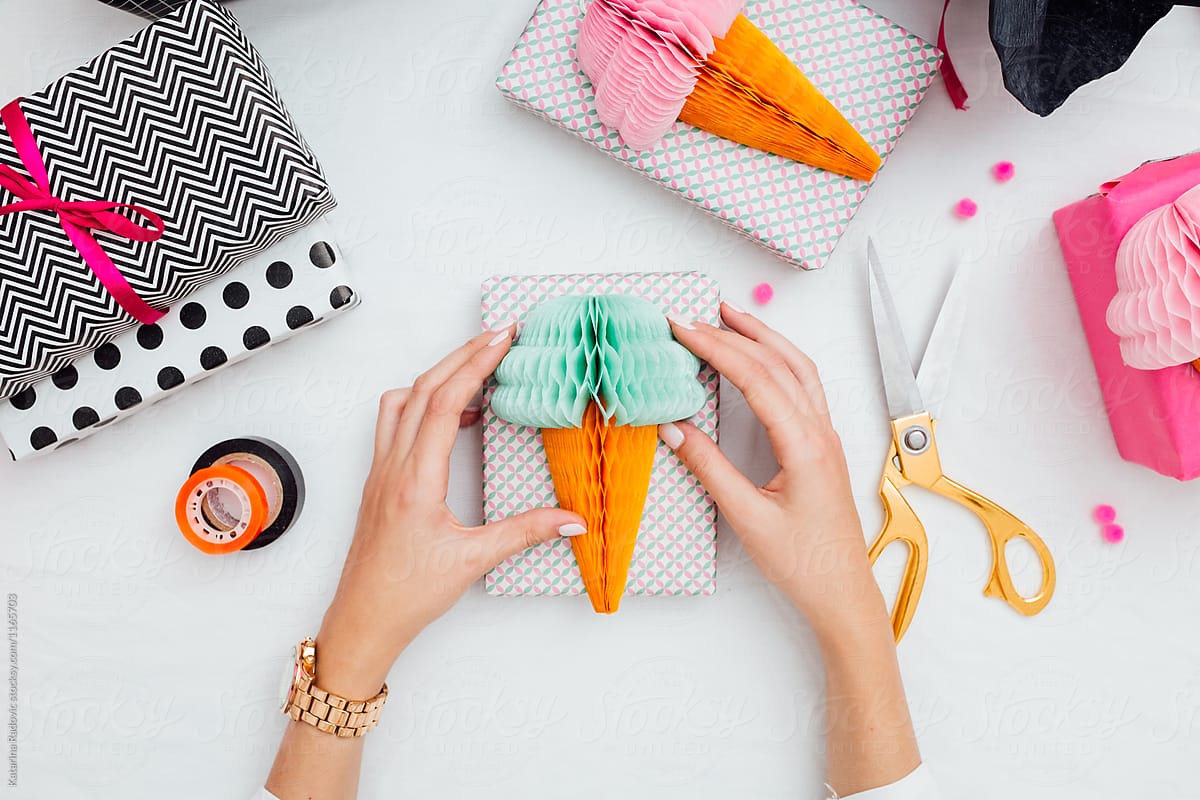 "Woman Wrapping Gifts" by Stocksy Contributor "Katarina Radovic" - Stocksy