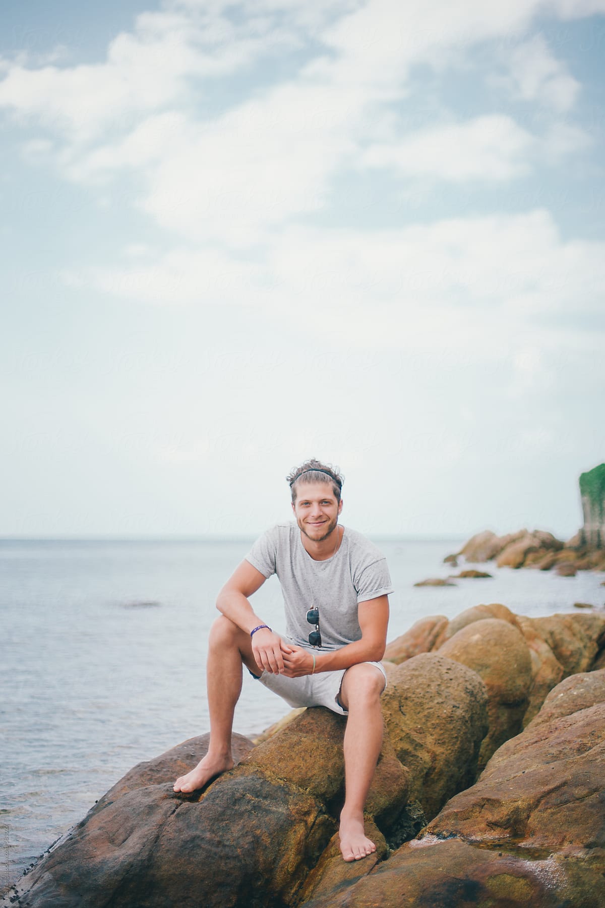 "Young Caucasian Man Sitting On The Rock By The Sea" by Stocksy ...