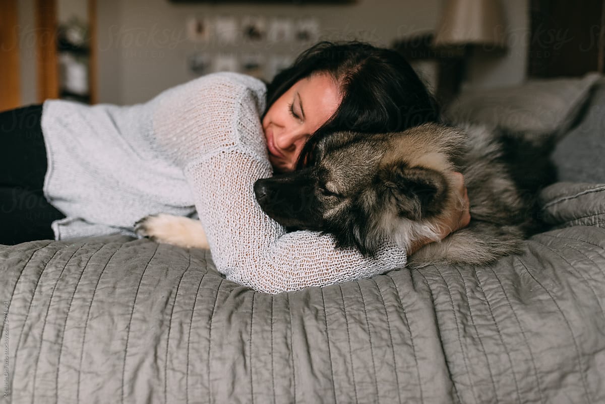 "Puppy Snuggles" by Stocksy Contributor "Melanie DeFazio" - Stocksy