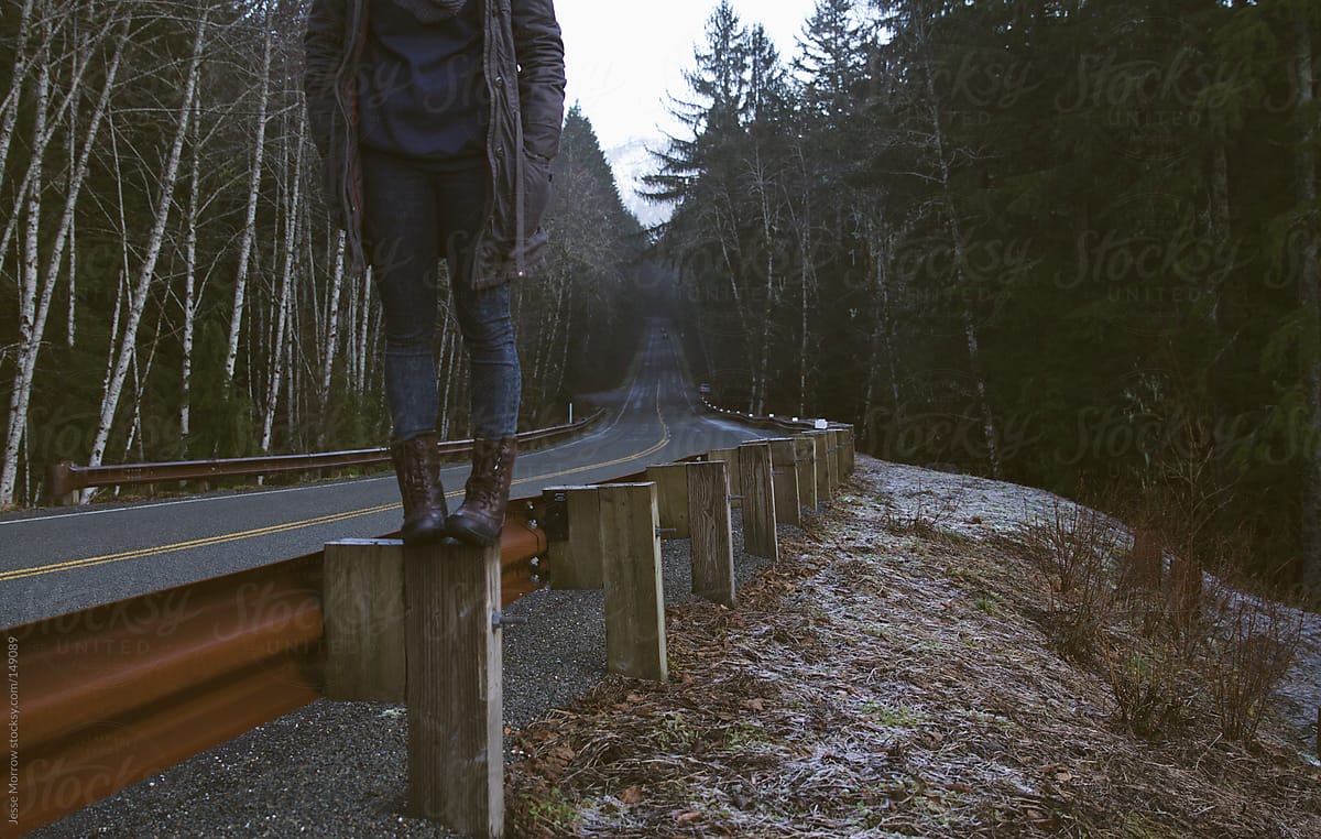 "Girl Stands On Guard Rail" by Stocksy Contributor "Jesse Morrow" - Stocksy