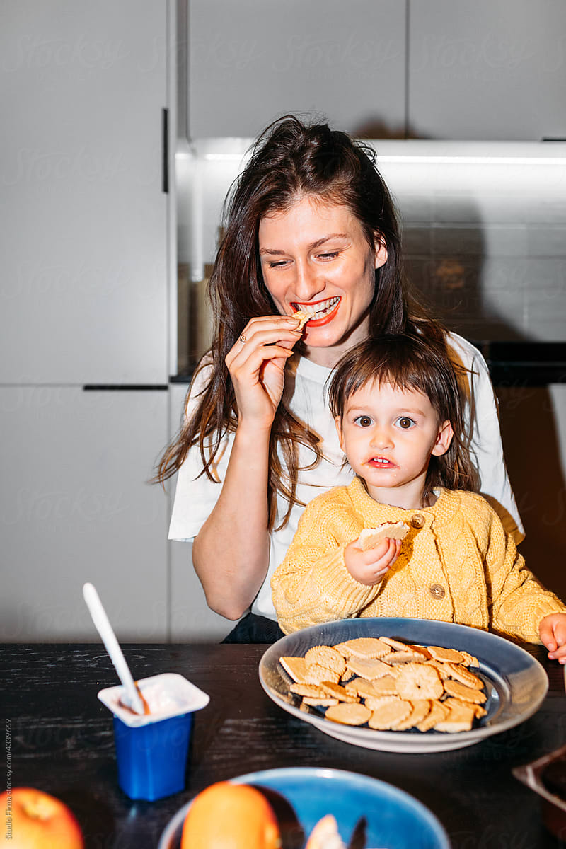 "Woman And Little Girl Eating Snacks" by Stocksy Contributor "Studio ...