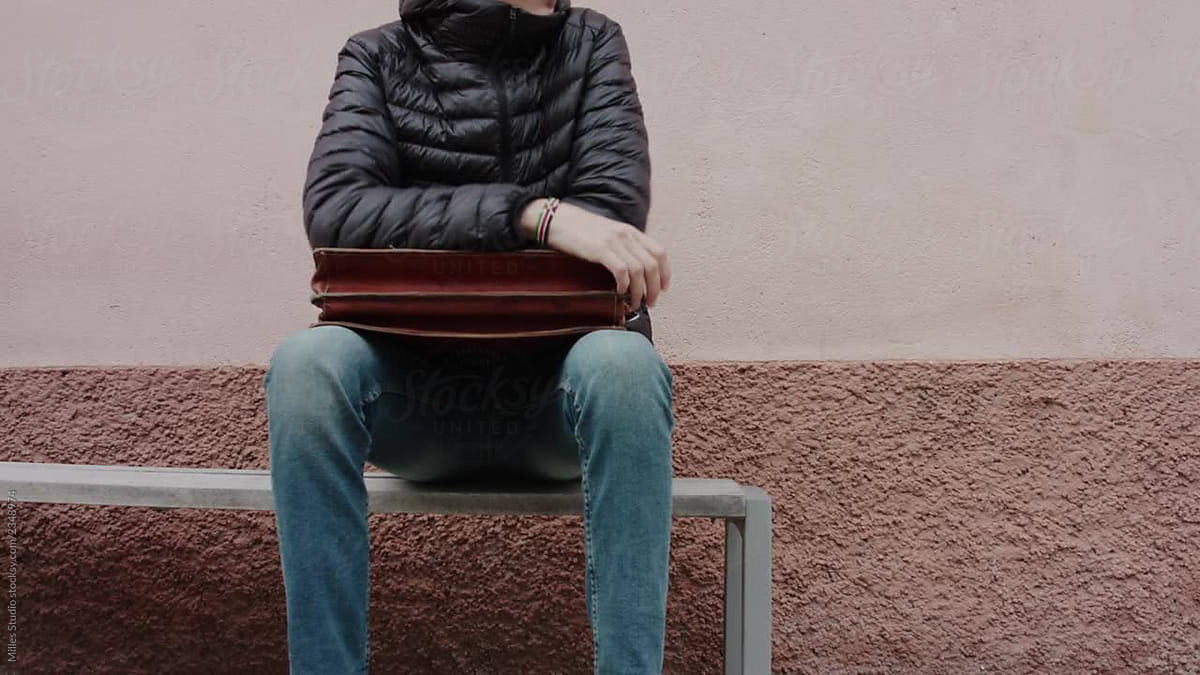 "Man Sitting On Bench With Bag" by Stocksy Contributor "Milles Team ...
