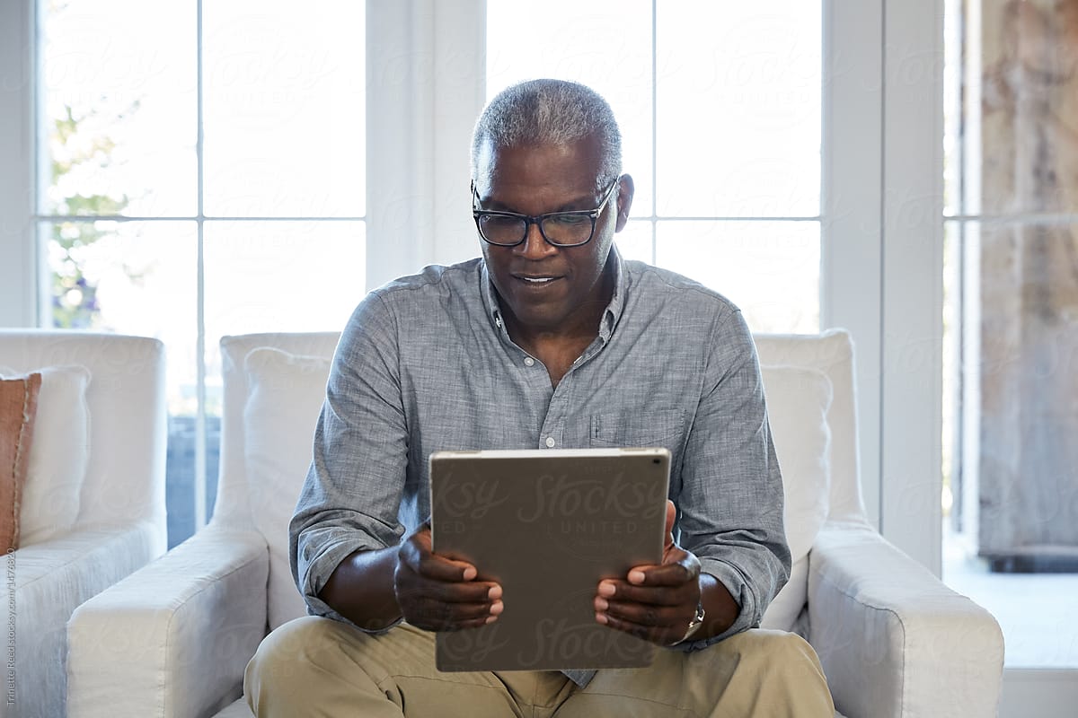"African American Senior Man Browsing The Internet On A Large Digital ...
