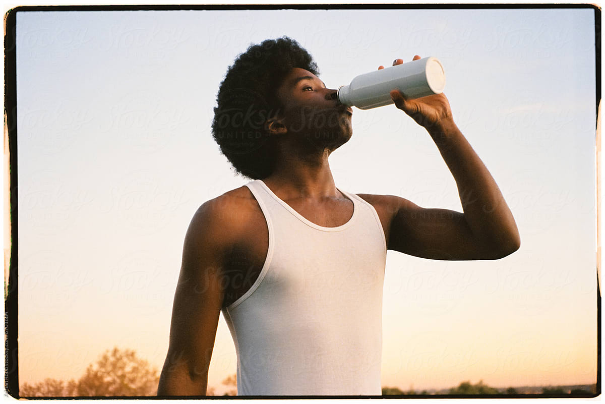 "Scanned Medium Shot Of A Healthy Young Afro Man Hydrating Himself" by ...