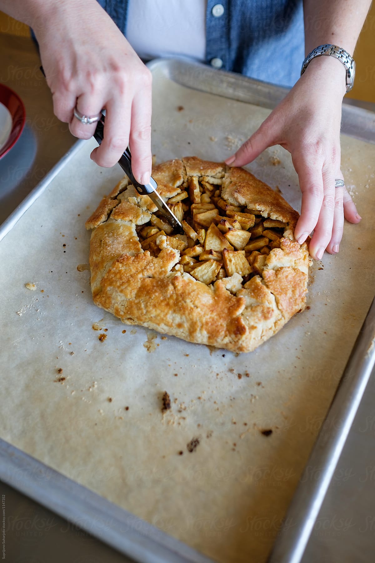 "Woman Cutting A Slice Of Baked Apple Pie In The Kitchen" by Stocksy ...