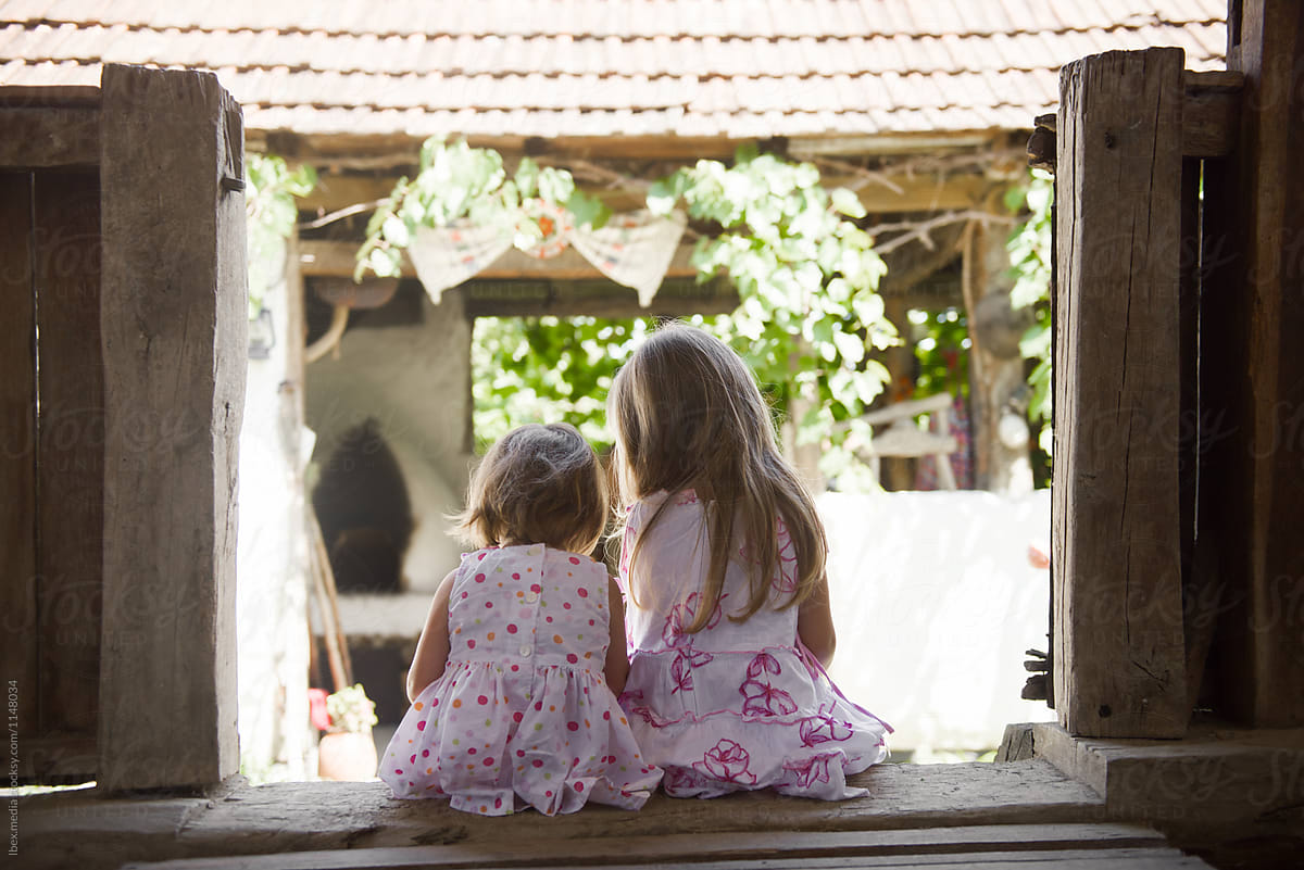 "Rear View Of Two Little Girls Sitting On House Porch" by Stocksy ...