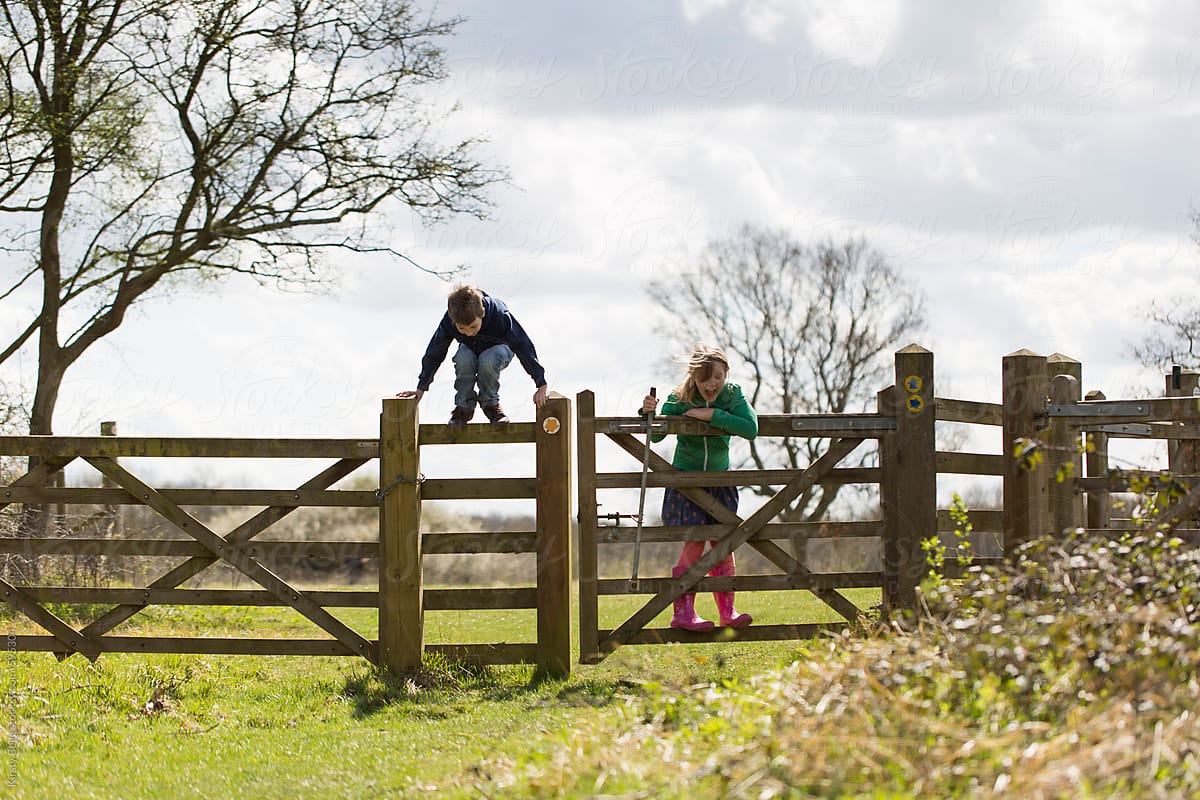 "Children Play On Fence In Countryside" by Stocksy Contributor "Kirsty ...