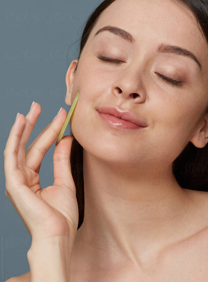 "Woman Using Gua Sha Crystal" by Stocksy Contributor "Leandro Crespi ...