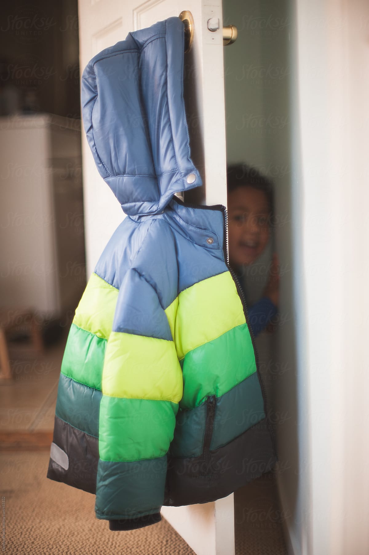 "Boy Peeks From Behind A Door With Winter Coat" by Stocksy Contributor ...
