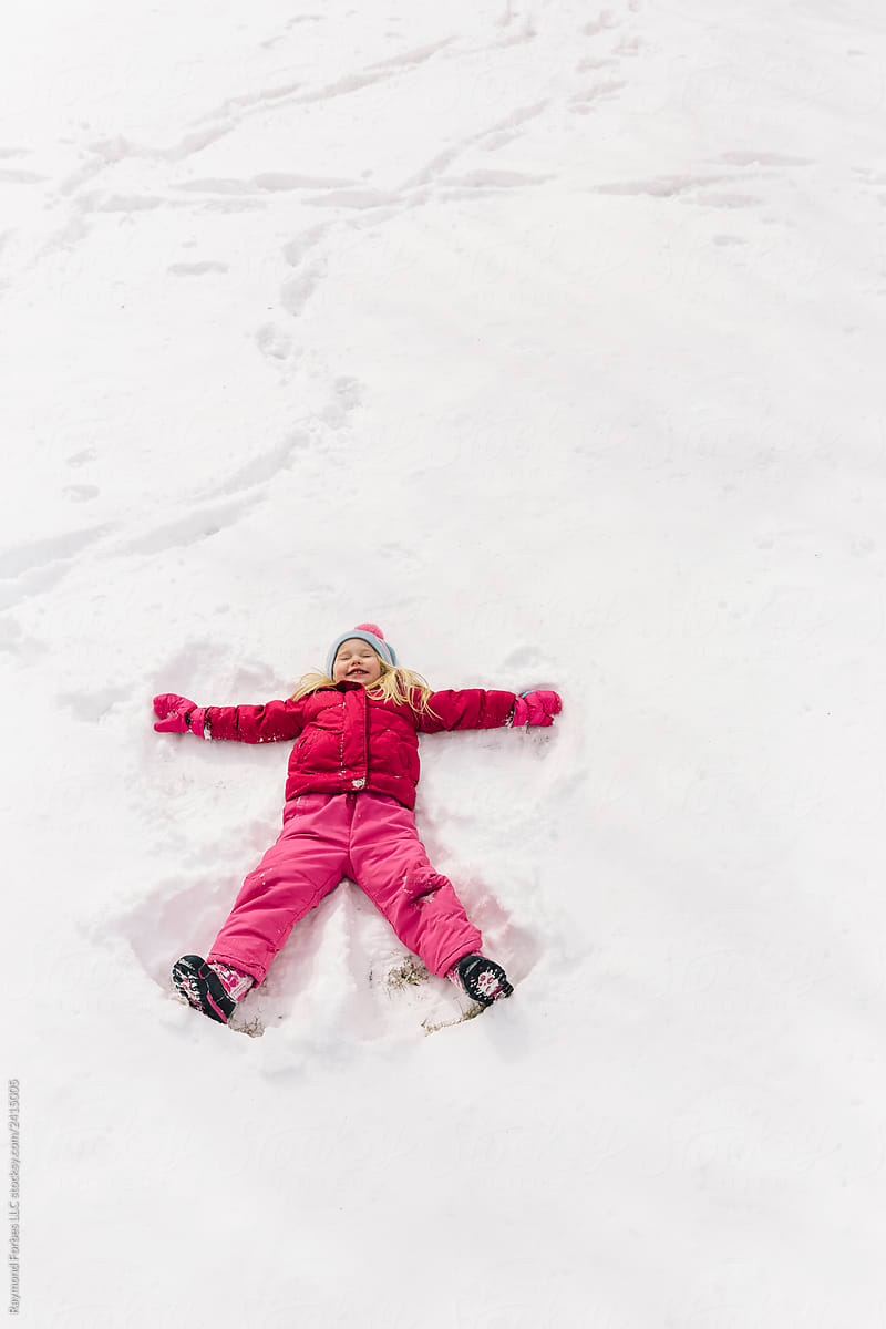 "Child In Snow Making Snow Angel" by Stocksy Contributor "Raymond ...