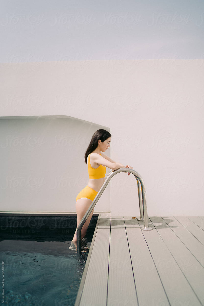 "Woman In Swimwear Standing On Swimming Pool Handrail Stairs" by ...