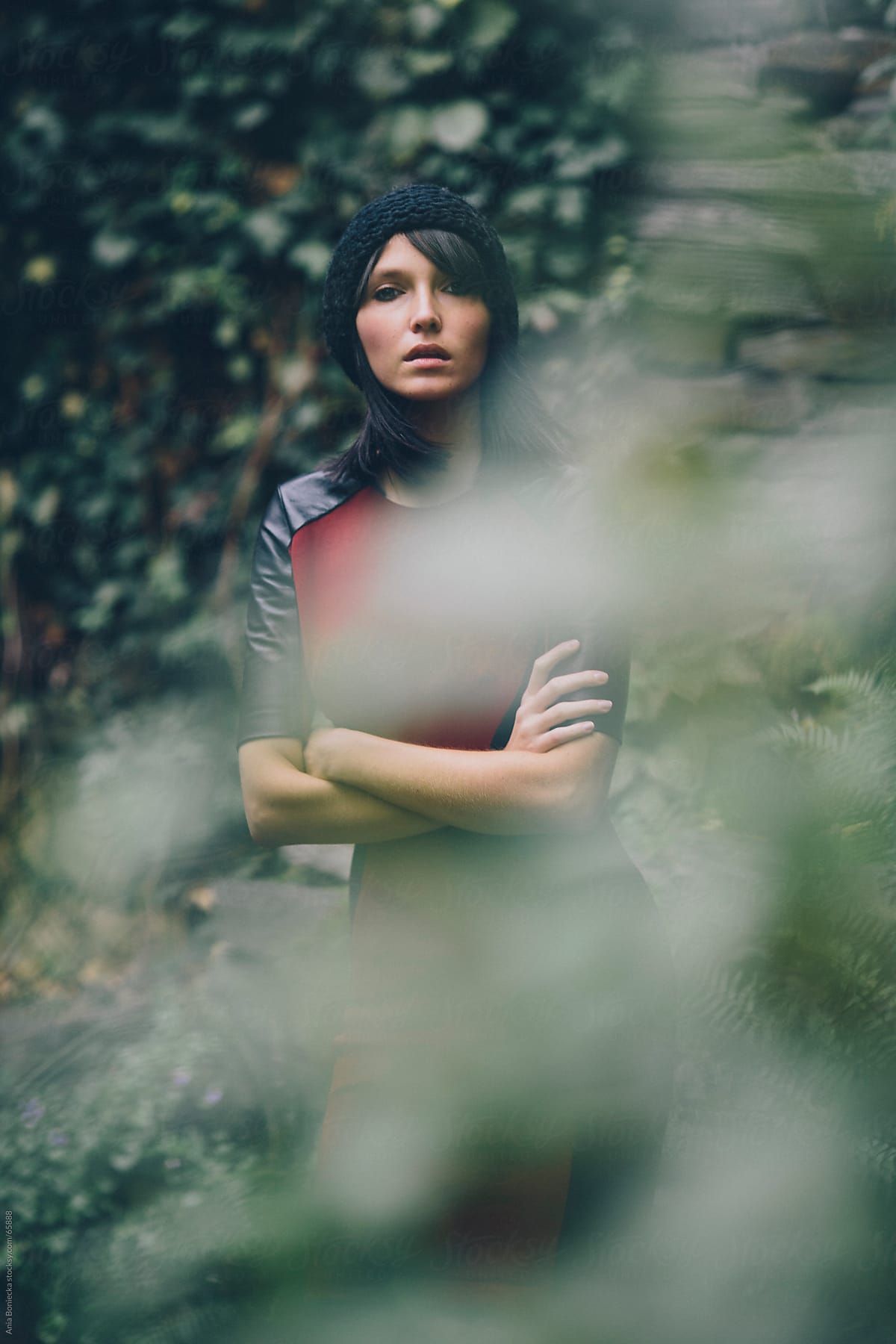 "Stylish Woman With Arms Crossed Behind A Blur Of Leaves" by Stocksy ...