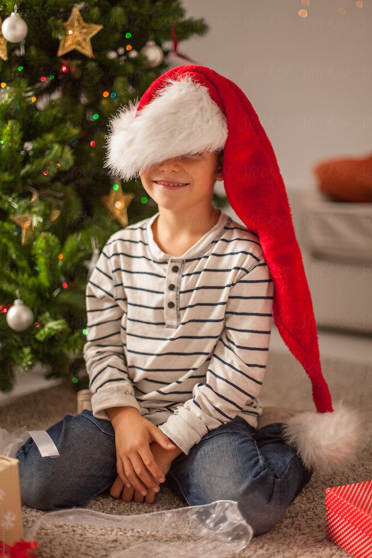 "Cute Boy Wearing Santa's Hat" by Stocksy Contributor "Mosuno" - Stocksy