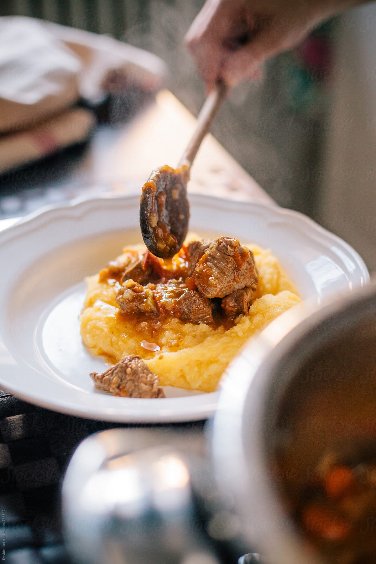 "Serving Beef Stew With Polenta" by Stocksy Contributor "Davide Illini ...