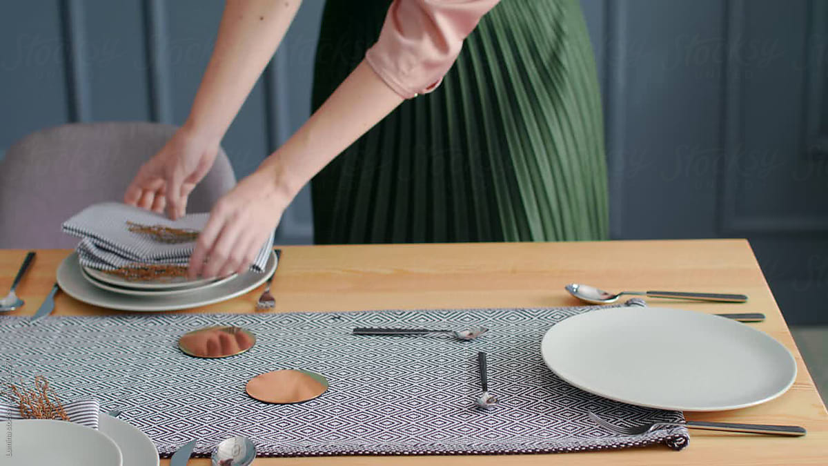 "Woman Setting Up Dinner Table" by Stocksy Contributor "Lumina" - Stocksy