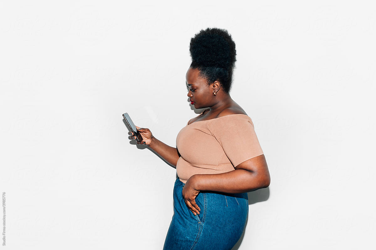 "African Woman Using Mobile Phone" by Stocksy Contributor "Studio Firma ...