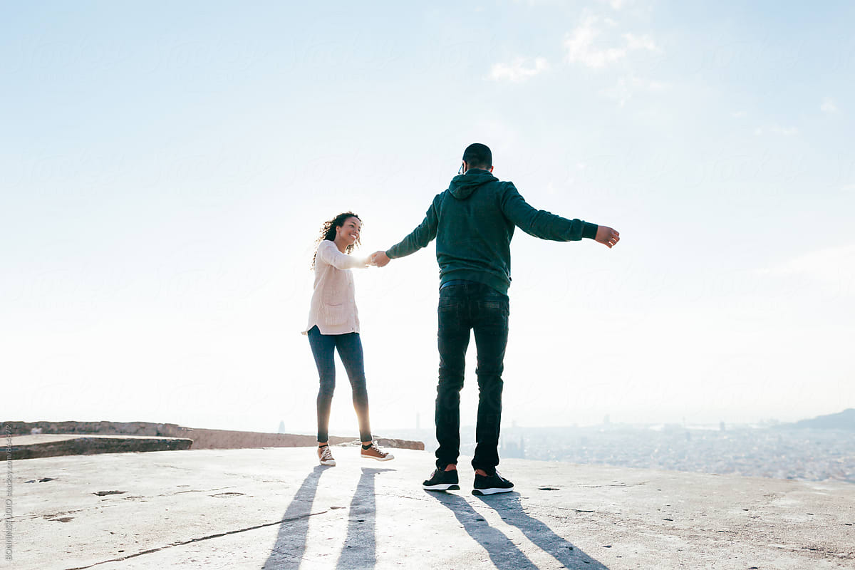 "Happy Mixed Race Couple Dancing Above City On A Sunny Day." by Stocksy ...