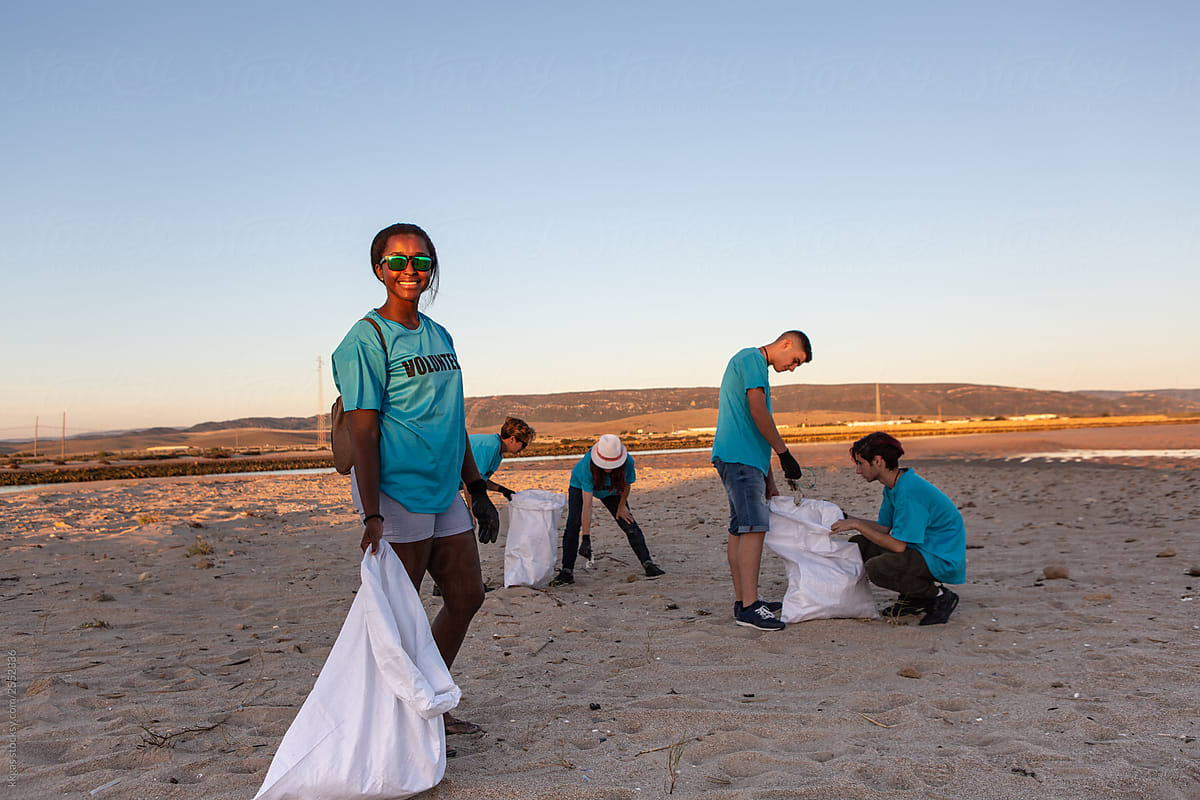 "Woman Smiling During Community Beach Clean" by Stocksy Contributor ...