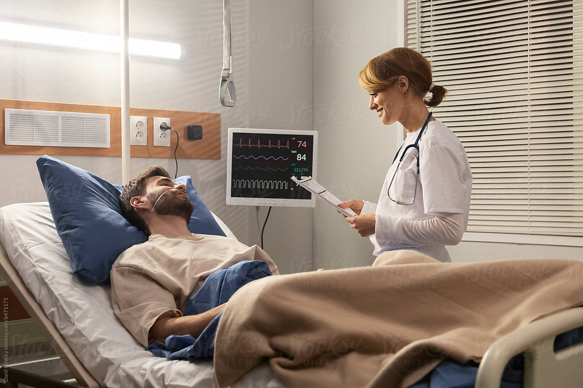 "Doctor Visiting Patient In Hospital Room Discussing Medical Chart" by ...