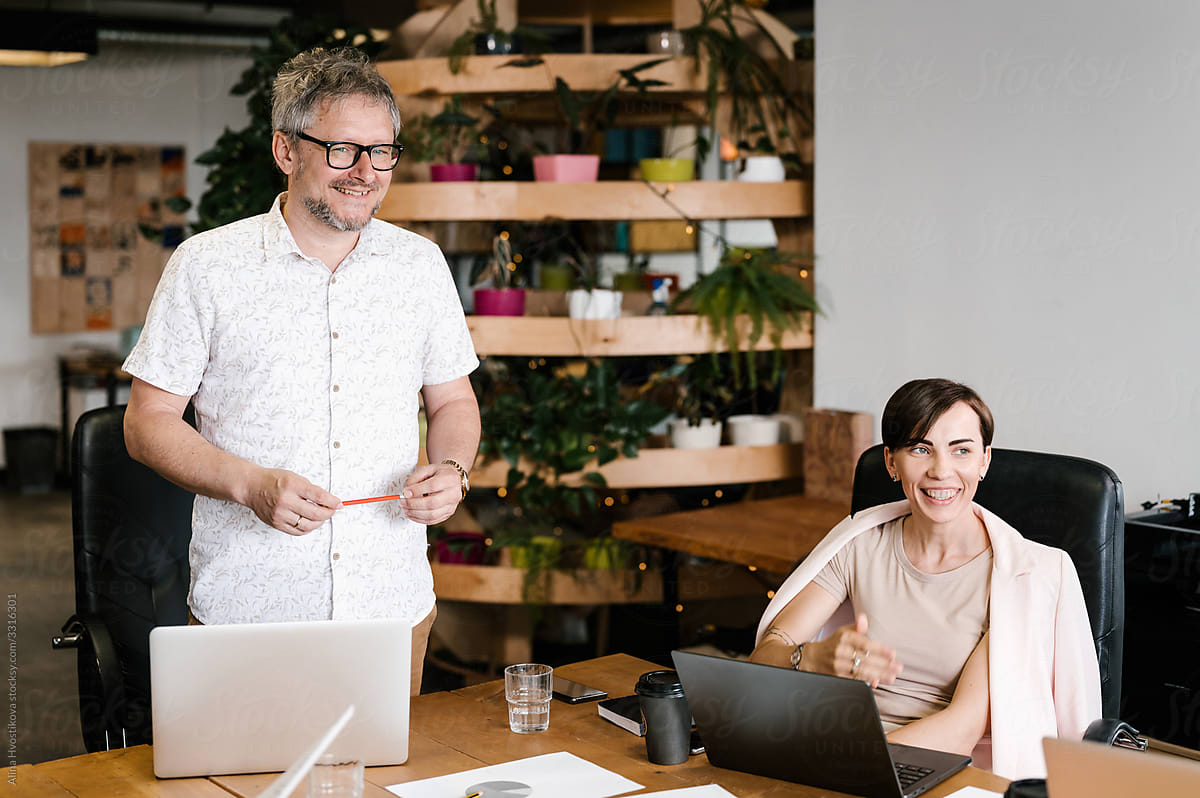 "Cheerful Colleagues Smiling During Meeting" by Stocksy Contributor ...