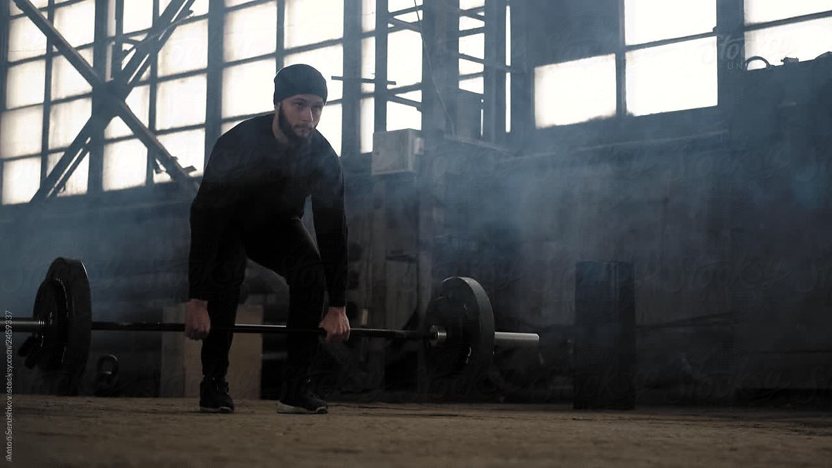 "Athlete Trains With A Heavy Weight In Textured Hangar." by Stocksy ...