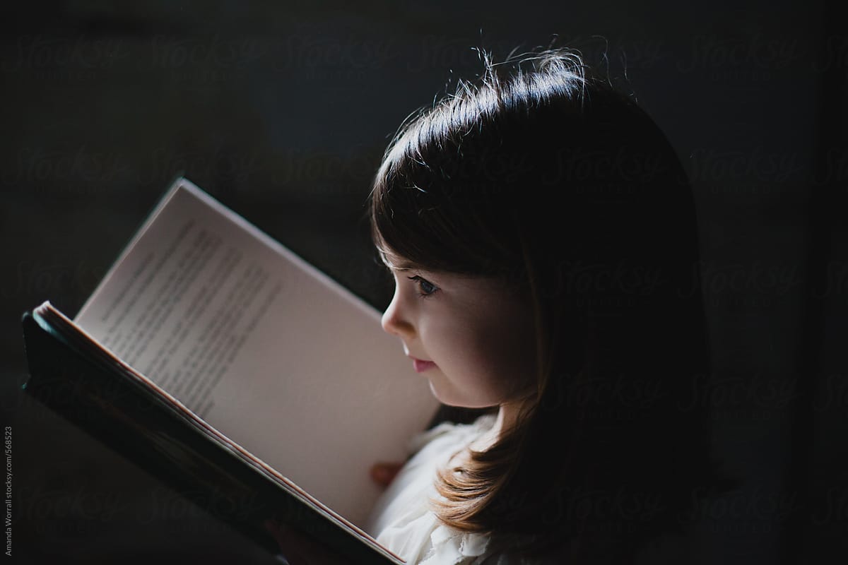 "Grinning Girl Looking At Book" by Stocksy Contributor "Amanda Worrall ...
