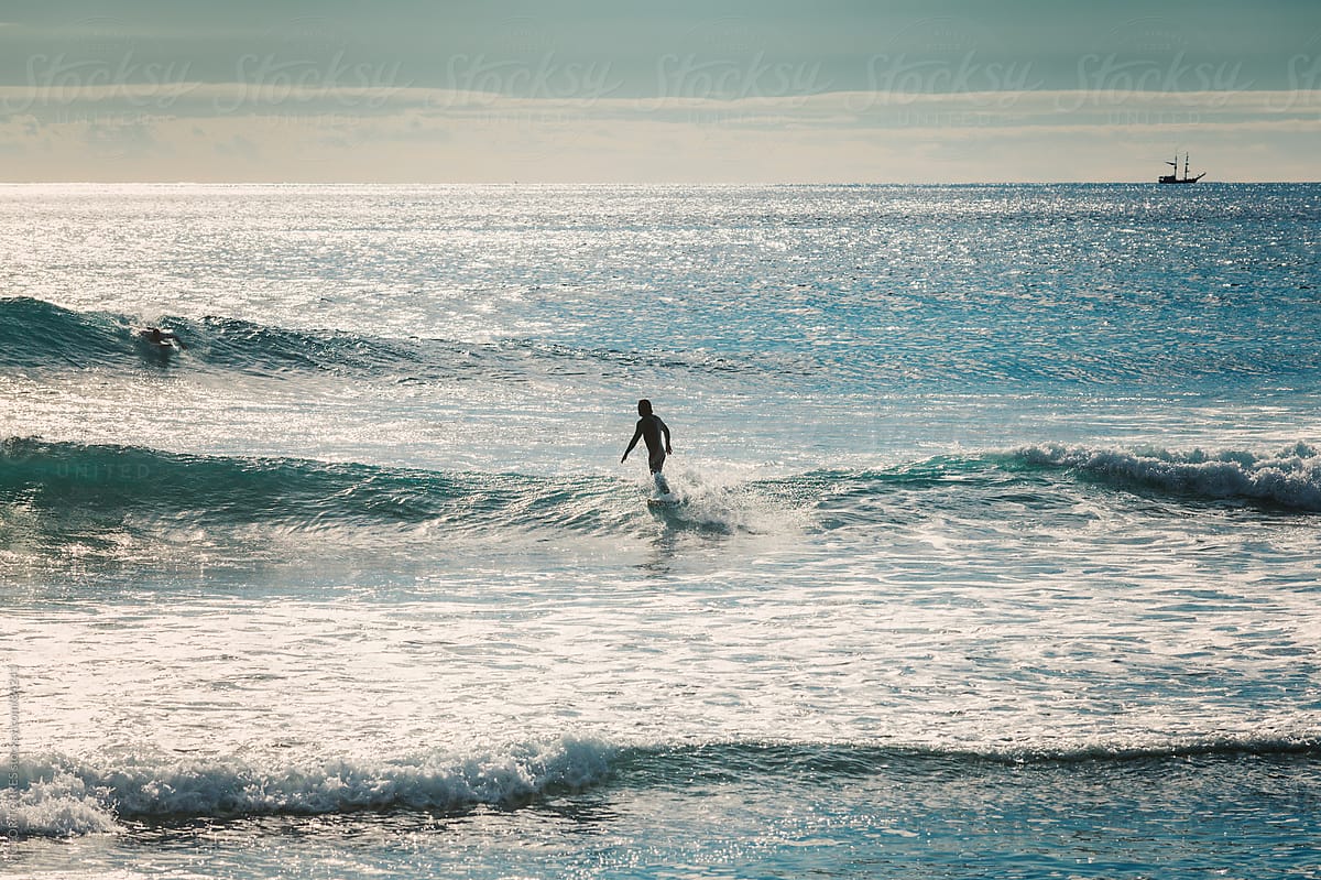 "Surfers At Sunset" by Stocksy Contributor "VICTOR TORRES" - Stocksy