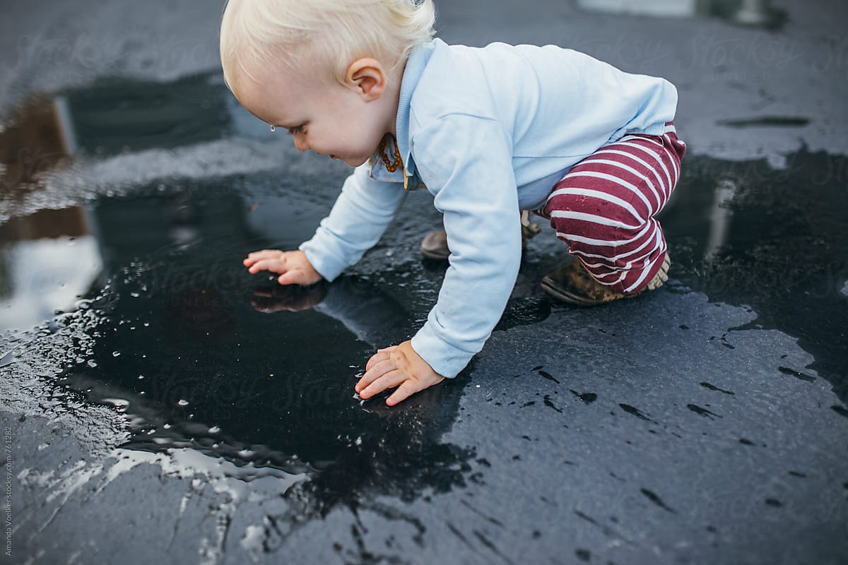 "Toddler Boy Smiles While Playing In A Puddle With HIs Hands" by ...