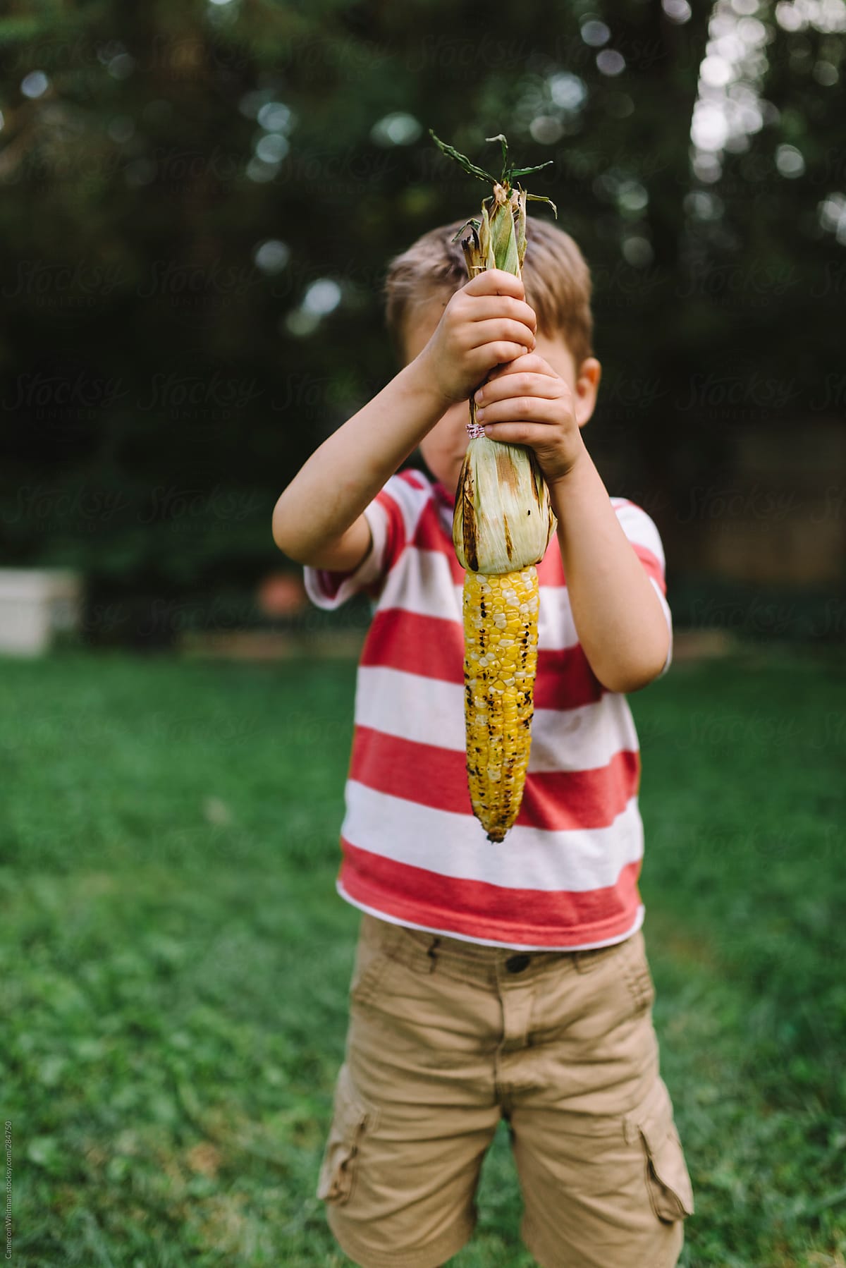 "Young Boy With Grilled Corn On The Cob In The Backyard" by Stocksy ...
