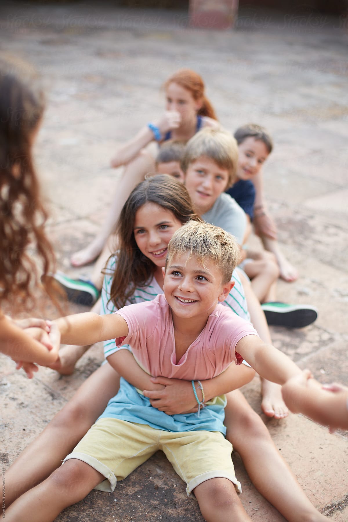 "Group Of Children Playing Together A Game Of Strength" by Stocksy ...