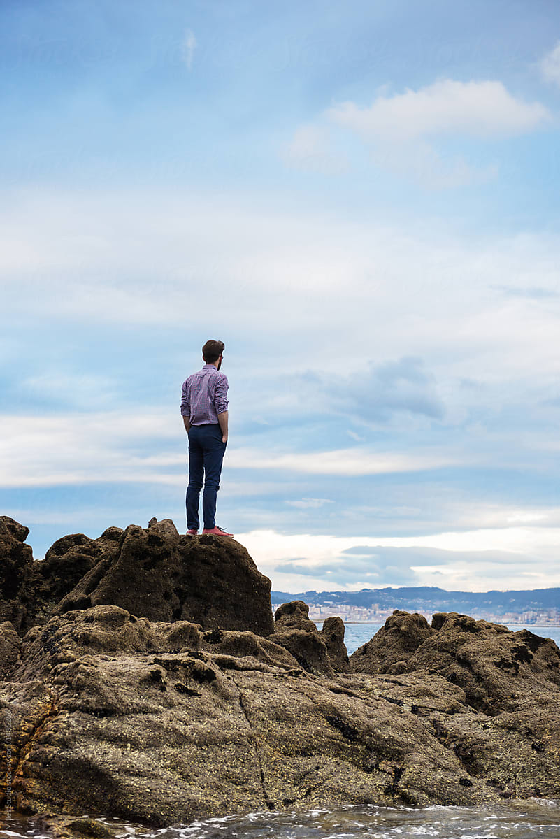 "Man On Stone looking At Sea" by Stocksy Contributor "Milles Team ...