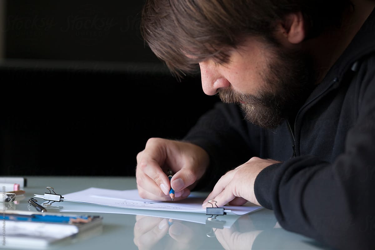 "Man Drawing On Table" by Stocksy Contributor "Robert Kohlhuber" - Stocksy