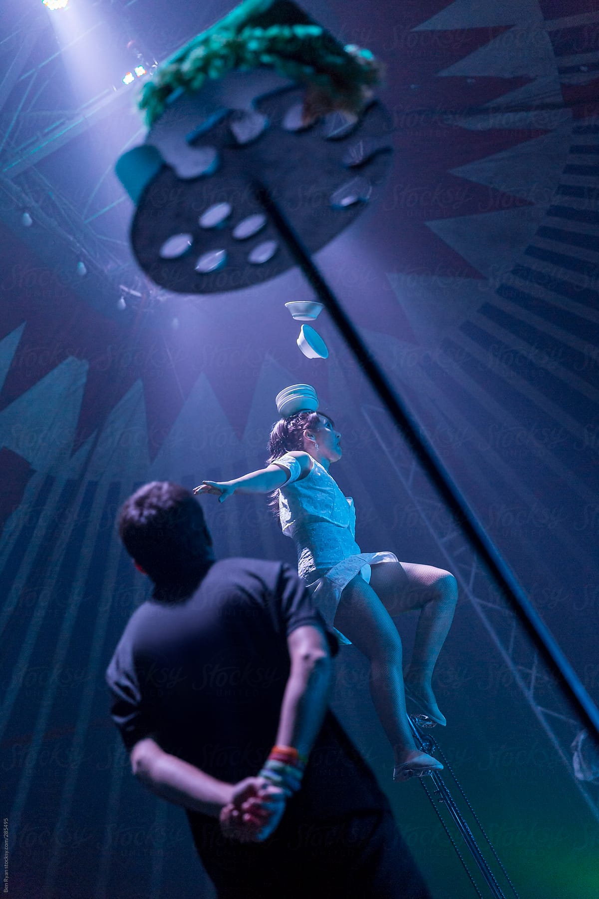 "Circus Performer On A Unicycle Balancing Multiple Bowls On Her Head ...